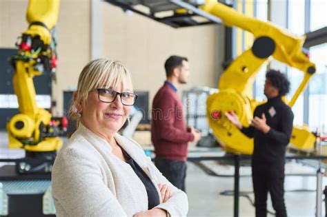 Confident Woman In Robotics Laboratory With Colleagues Discussing