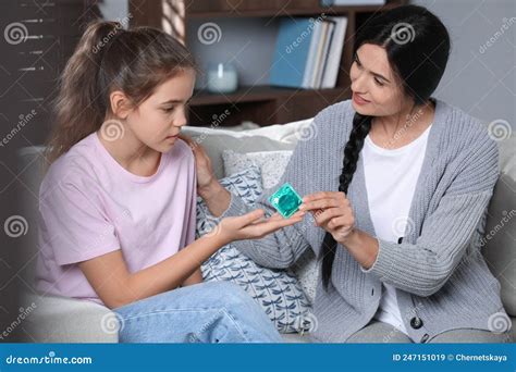 Mother Giving Condom To Her Teenage Daughter At Home Sex Education