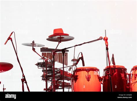 A Stage Drum Set Is Illuminated By Red Lighting Featuring Various