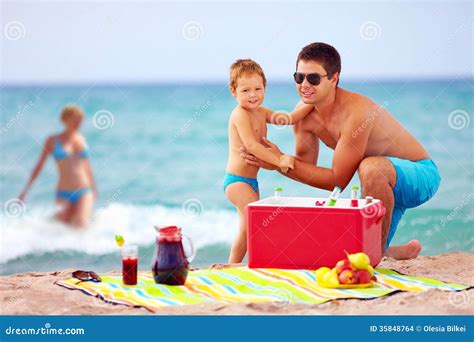 Счастливая семья на пикнике пляжа лета Стоковое Фото изображение