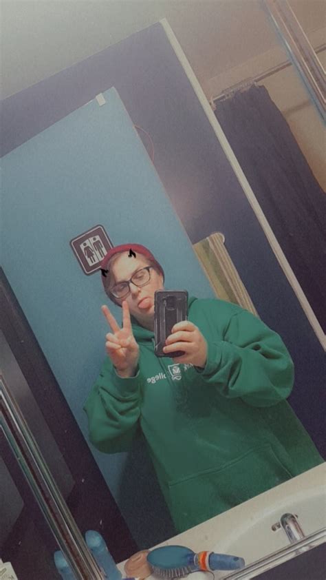 A Non Binary Person Taking A Selfie On Snapchat Standing In Front Of