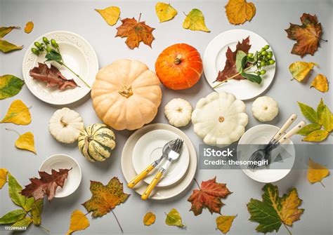 다양한 형형색색의 호박 단풍 파티와 축하를 위해 준비된 밝은 회색 배경 테이블에 수저가 있는 빈 접시가 있는 추수감사절 축제 테이블 구성 10월에 대한 스톡 사진 및 기타