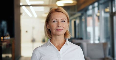 50 대 간부 경력 권한을 부여받은 금발의 금발의 여자 기업 환경 기업가 동기 부여 된 리더십 만족 매력적인 미소 짓는 보고 있는 비즈니스