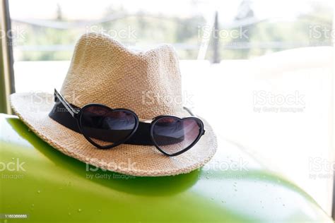 해변 여름 액세서리입니다 하트 모양의 선글라스와 세련된 니트 밀짚 모자가 풍선 원에 놓여 있습니다 최소한의 여름 개념 공간을