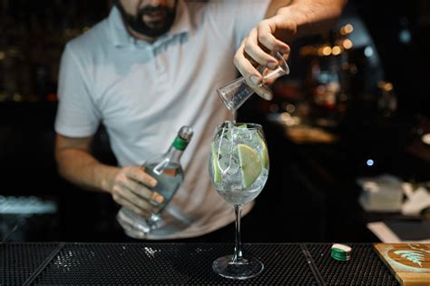 남자 바텐더는 어두운 배경에 화이트 와인 얼음 조각 사과 조각을 추가하여 맛있는 칵테일을 만듭니다 라이프스타일 나이트클럽 나이트클럽에 대한 스톡 사진 및 기타 이미지