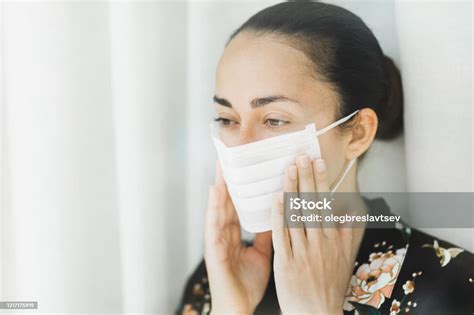 코로나바이러스 검역소에서의 자기 격리 의료 용 마스크를 착용 하는 여자입니다 창을 통해 볼 수 있습니다 바이러스 확산 의 예방