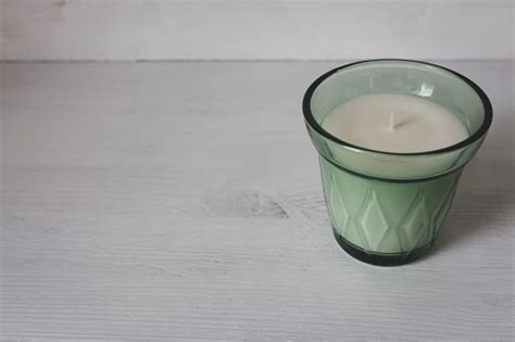 흰색 나무 선반에 녹색 유리 화병에 촛불 대처 공간과 흰색 배경에 새로운 촛불 아로마테라피 컨셉 향기로운 촛불은 고립되어 있습니다 홈 인테리어 럭셔리 라이프 스타일 0명에