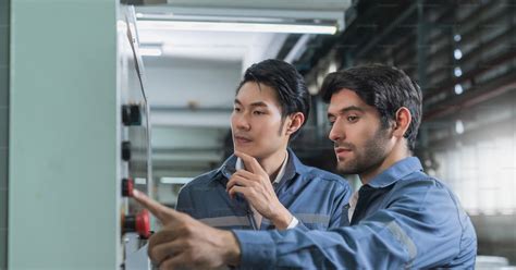 남성 아시아 백인 엔지니어 전문가는 공장에서 기계에서 토론 서 상담 두 명의 전문 동료가 설명하고 Cnc 작동 기계의 프로세스를 해결합니다 사진 Unsplash의
