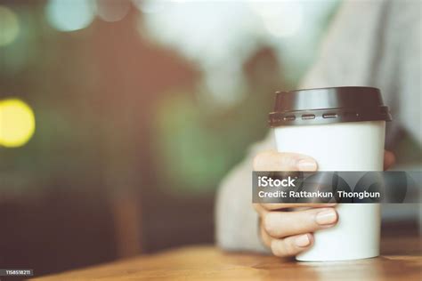 젊은 여자 손 들고 종이 컵 의 테이크 아웃 마시는 커피 뜨거운 에 테이블 나무 에 카페 커피 숍 커피잔에 대한 스톡 사진 및 기타 이미지 Istock
