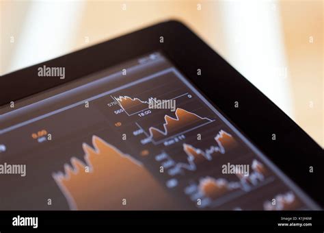 Analyzing Stock Market From A Digital Tablet Over A Detailed Diagram