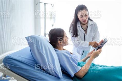 아시아 여성 의사 치료 병원 배경에 침대에 젊은 여성 환자에 게 태블릿조언 2명에 대한 스톡 사진 및 기타 이미지 2명 건강 진단 건강관리와 의술 Istock