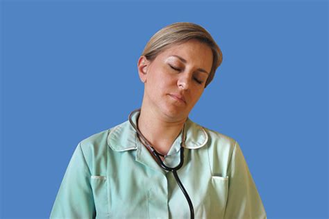 의사 또는 간호사 수 면 피곤 하 고 지친 여자 유니폼에는 하드 듀티 후 병원이 나 클리닉에서 자 고 있다 목과 닫힌 눈 주위의 청진 기를 가진 암컷은 벽에 기대어 있는