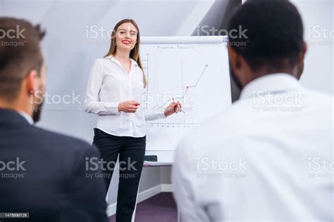 자신감 있는 여성 비즈니스 코치 플립차트에 대한 프레젠테이션 고객 교육자 컨설팅 팀 코칭 사람들 이야기 마케팅 세미나 개념의 전략 설명 20 24세에 대한 스톡 사진 및