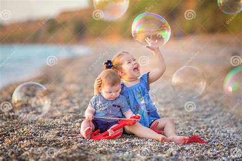Brother And Sister Playing In The Shore Break On The Beach During The