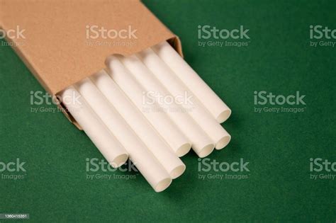 복사 공간이있는 녹색 배경에 크래프트 종이 상자에 흰색 종이 빨대의 모형 이미지 생분해성 마시는 빨대 지속 가능한 라이프 스타일과 폐기물 제로 개념 종이 빨대에 대한 스톡