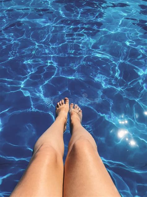 Tanned Girl Legs In A Pool With Blue Water In Sunny Light Top View