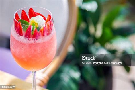 딸기 민트 꽃잎이 테라스를 배경으로 테이블 위에 서있는 유리에 칵테일 딸기에 대한 스톡 사진 및 기타 이미지 딸기 펀치 칵테일 0명 Istock