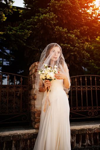 울타리에 꽃다발과 함께 베일 아래 긴 물결 모양의 머리를 가진 신부 개인 장식품에 대한 스톡 사진 및 기타 이미지 개인 장식품 결혼 반지 결혼식 Istock