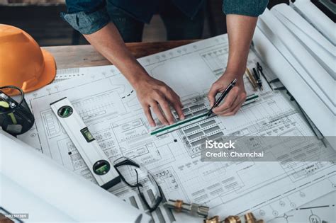 사무실 책상과 계산기 삼각형 눈금자 안전 안경 나침반 블루프린트의 버니어 캘리퍼에서 도면 검사 및 쓰기로 작업하는 엔지니어링 엔지니어 건축가 산업 및 공장 개념 35 39