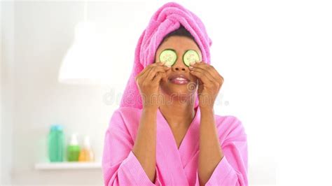African American Woman In Spa Playing With Cucumber Slices Stock