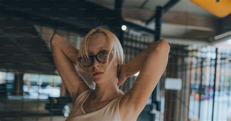 금발 머리와 안경을 쓴 여자가 노란 물체를 들고 있다 사진 Unsplash의 여자 이미지