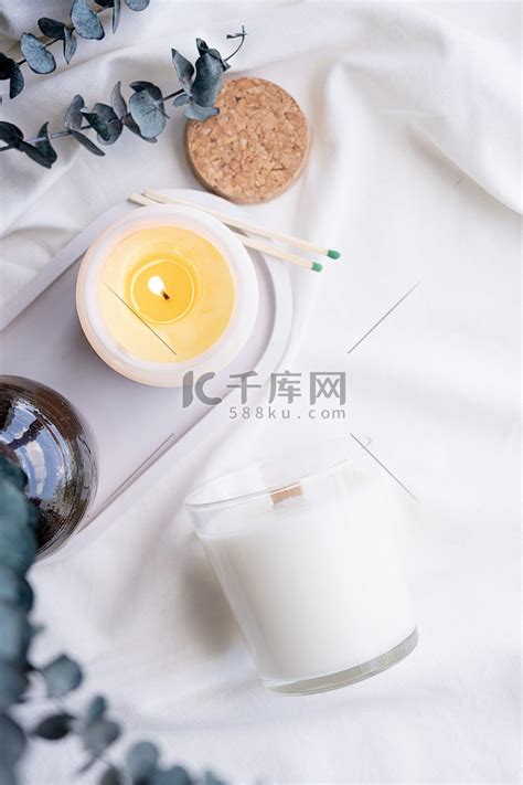 大豆蜡香薰蜡烛放在床上的白色罐子里上面放着桉树叶高清摄影大图 千库网
