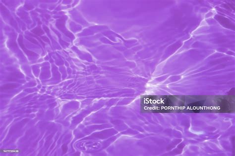 디포커스는 투명한 보라색 투명한 잔잔한 물 표면 질감을 스플래쉬 버블로 흐리게 처리했습니다 빛나는 보라색 물 잔물결 배경 수영장에서 물의 표면 보라색 거품 물이 빛납니다 0