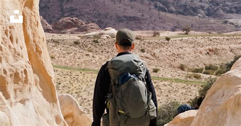 배낭을 메고 있는 남자가 바위 사이를 걷고 있다 사진 Unsplash의 무료 요르단 이미지