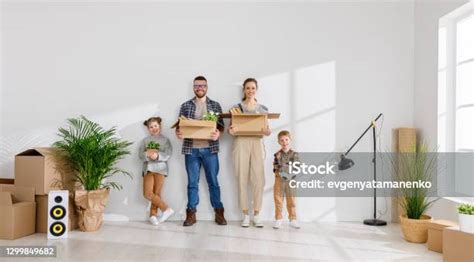 행복한 가족 어머니 아버지와 아이들은 새 아파트로 이사하여 빈 벽에 상자에 상자를 들고 줄지어 서 있습니다 4 명에 대한 스톡 사진 및 기타 이미지 Istock