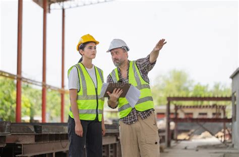 Senior Engineer And Female Foreman Team Checking Project At Precast Concrete Factory Site