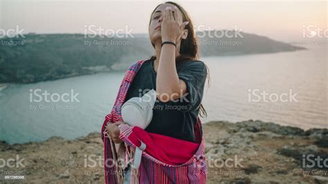 Gozo 몰타에서 아름 다운 해변과 바다의 Ramla만 칼 립 소 비스 뷰 근처 서 있는 담요와 캐주얼 옷에 갈색 여행자 여자를 닫습니다 경관에 대한 스톡 사진 및 기타