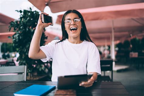 소셜 네트워크에서 좋은 소식을 즐기며 의사 소통을하기 위해 현대 기술을 사용하는 백인 여성 블로거 태블릿과 스마트 폰을 개최하는 경연 대회에서 승리 한 감정적 인 여성 20