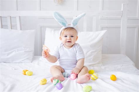 토끼 귀와 집에서 흰 침대에 화려한 달걀을 가진 귀여운 아기 소년 작은 금발 아기 행복한 부활절 개념 4월에 대한 스톡 사진 및 기타 이미지 Istock
