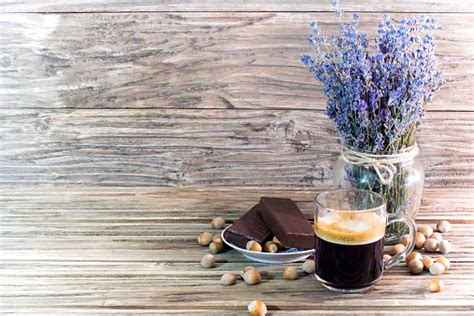 초콜릿 케이크 헤이즐넛과 라벤더는 오래 된 거친 나무와 배경에 백색 바 림의 꽃다발 유리 찻잔에 향기로운 블랙 커피의 사진 0