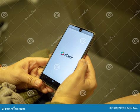 Woman Opening Slack Mobile Communication App With Logo On Android Screen While Commuting On