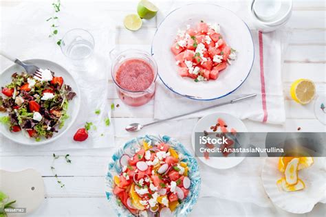 원시 신선한 여름 과일과 흰색 나무 바탕에 딸기 샐러드의 다양 한 냅킨 음료와 함께 제공 됩니다 여름철 유기 쉬운 라이프 스타일 개념입니다 평면 복사 공간을 놓으십시오