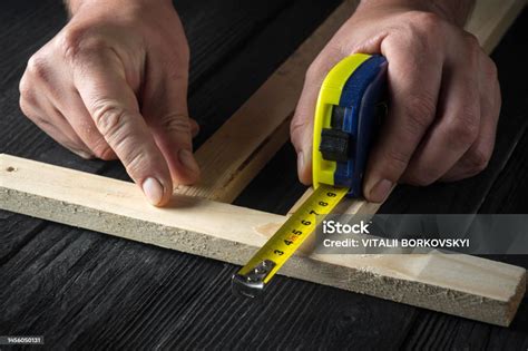 목수는 건설 테이프를 사용하여 나무 조각의 길이를 측정합니다 직장에서 주인의 손을 클로즈업합니다 목공 작업장의 작업 환경 개선에 대한 스톡 사진 및 기타 이미지 Istock
