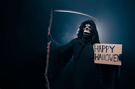 해골 두개골 검은 가운을 입은 남자의 실루엣 해피 할로윈 포스터를 들고 죽음을 묘사합니다 무서운 저승사자 할로윈을 위한 죽음의 저승사자 의상 할로윈 캐릭터 컨셉입니다 개념에