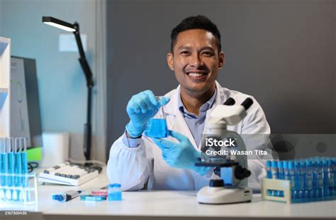 실험실에서 화학 물질을 실험하는 과학자 실험실에서 새로운 화학 물질에 대한 연구를 수행하는 실험실 기술자가 원뿔형 플라스크에 용액을 추가합니다 40 44세에 대한 스톡 사진