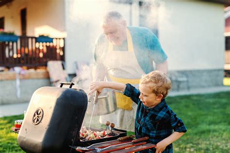 그의 손자는 막대기에 야채와 고기를 굽고 있는 동안 냄비를 들고 할아버지 가족 주말 개념에 수집입니다 가정 생활에 대한 스톡 사진 및 기타 이미지 Istock