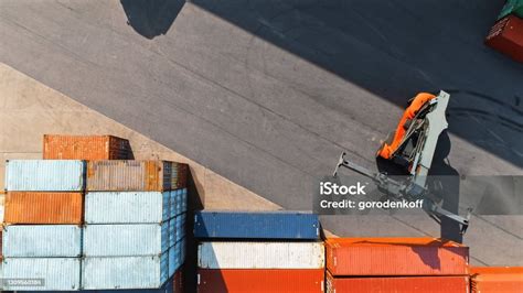 조선소 터미널에서 대형 빨간 화물 컨테이너를 운반하는 컨테이너 핸들러의 공중 탑 다운 샷 기계의 운전자는 물류 센터 창고에 상자를로드하고 있습니다 0명에 대한 스톡 사진 및