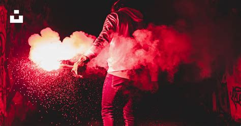 검은 색과 흰색 줄무늬 까마귀를 입은 사람이 붉은 연기로 무대에 서있다 사진 Unsplash의 무료 플레어 이미지