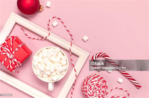 마시멜로 캔디 지팡이 선물 상자 빨간 공 포장 레이스 사진 프레임 핑크 배경 상단보기 플랫 레이와 화이트 머그잔 겨울 전통 음료