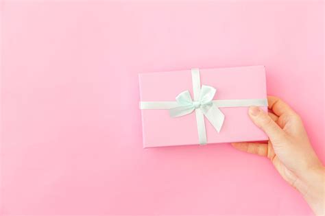 분홍색 파스텔 컬러풀한 트렌디한 배경에 고립된 분홍색 선물 상자를 들고 있는 여성 손 배달에 대한 스톡 사진 및 기타 이미지 배달 보석 개인 장식품 상자 Istock