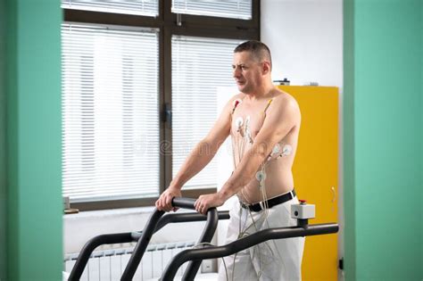 A Middle Aged Man Is Undergoing A Medical Stress Test On A Treadmill Connected To Ecg
