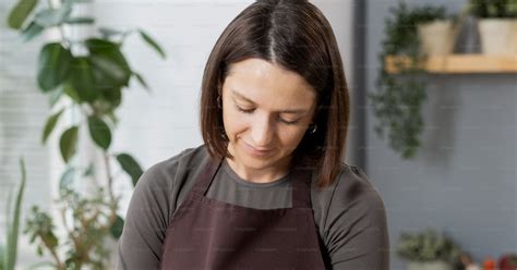 젊은 예쁜 여자는 부엌 테이블 옆에 서서 저녁 식사를 위해 음식을 요리하는 동안 나무 보드에 양파를 절단 사진