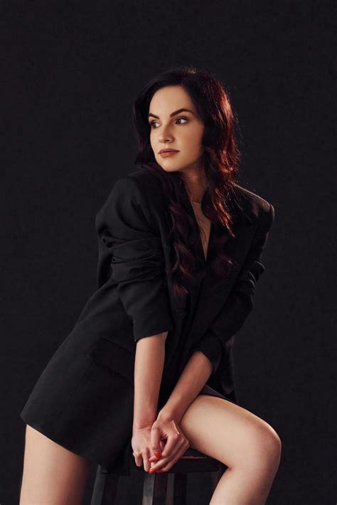 Sexy Brunette With Curly Hair In Luxury Clothes Sits On Chair In The