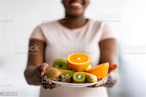 슬리밍 다이어트 체중 감소 와 건강 한 라이프 스타일 실내에서 과일 접시를 들고 플러스 크기의 흑인 여성의 자른 보기 과일에