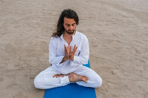 Premium Photo Full Length Of Man Meditating On Beach