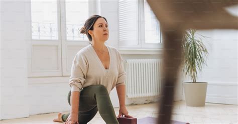 가벼운 스튜디오에서 장비를 갖춘 스포츠웨어 Ptactice 요가를 입은 매력적인 중년 갈색 머리 여자 사진 Unsplash의